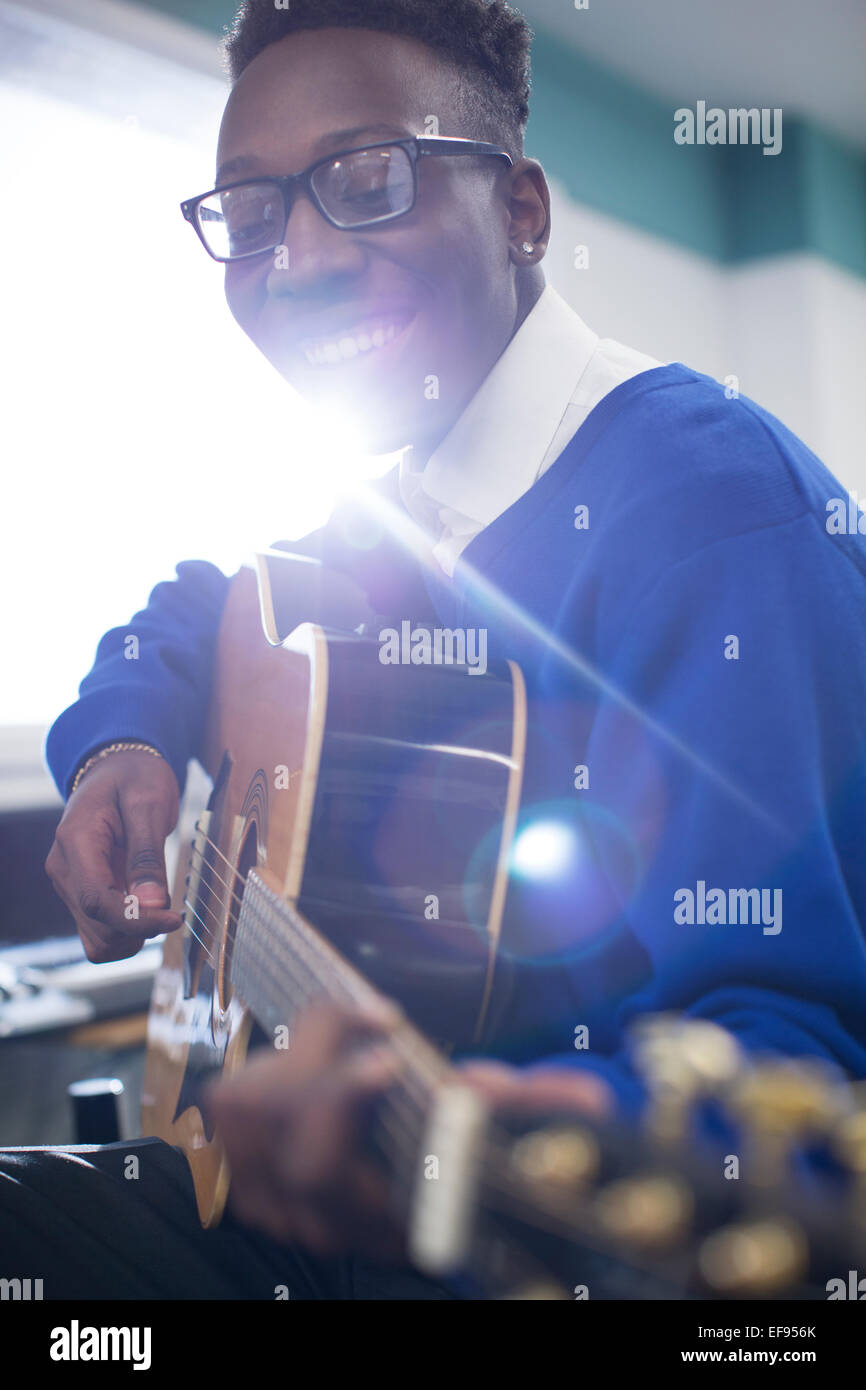 Young student playing acoustic guitar in classroom Stock Photo - Alamy