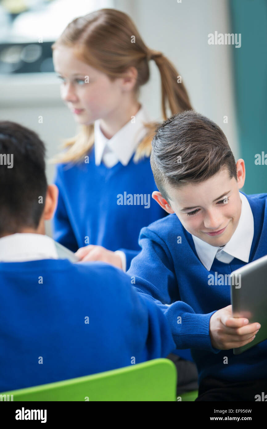 Elementary school children wearing blue school uniforms in classroom ...