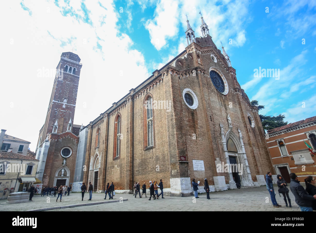 People walking on the square Campo dei Frari in front of the Basilica ...