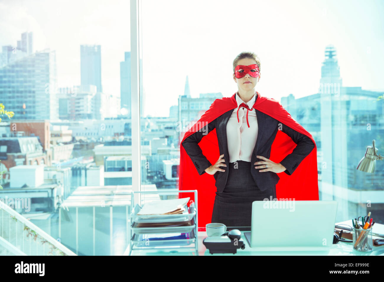Businesswoman wearing cape and mask in office Stock Photo - Alamy