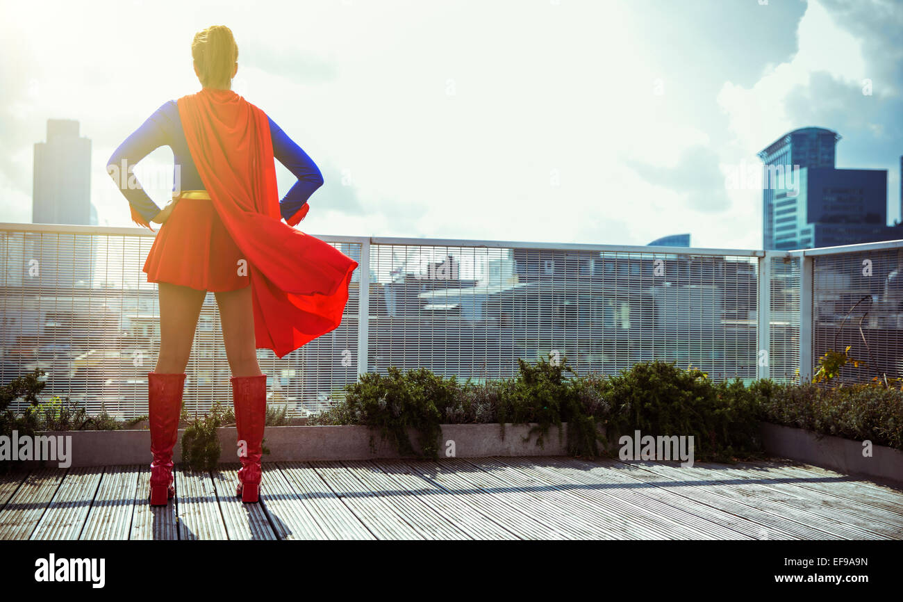 Superhero standing on city rooftop Stock Photo - Alamy