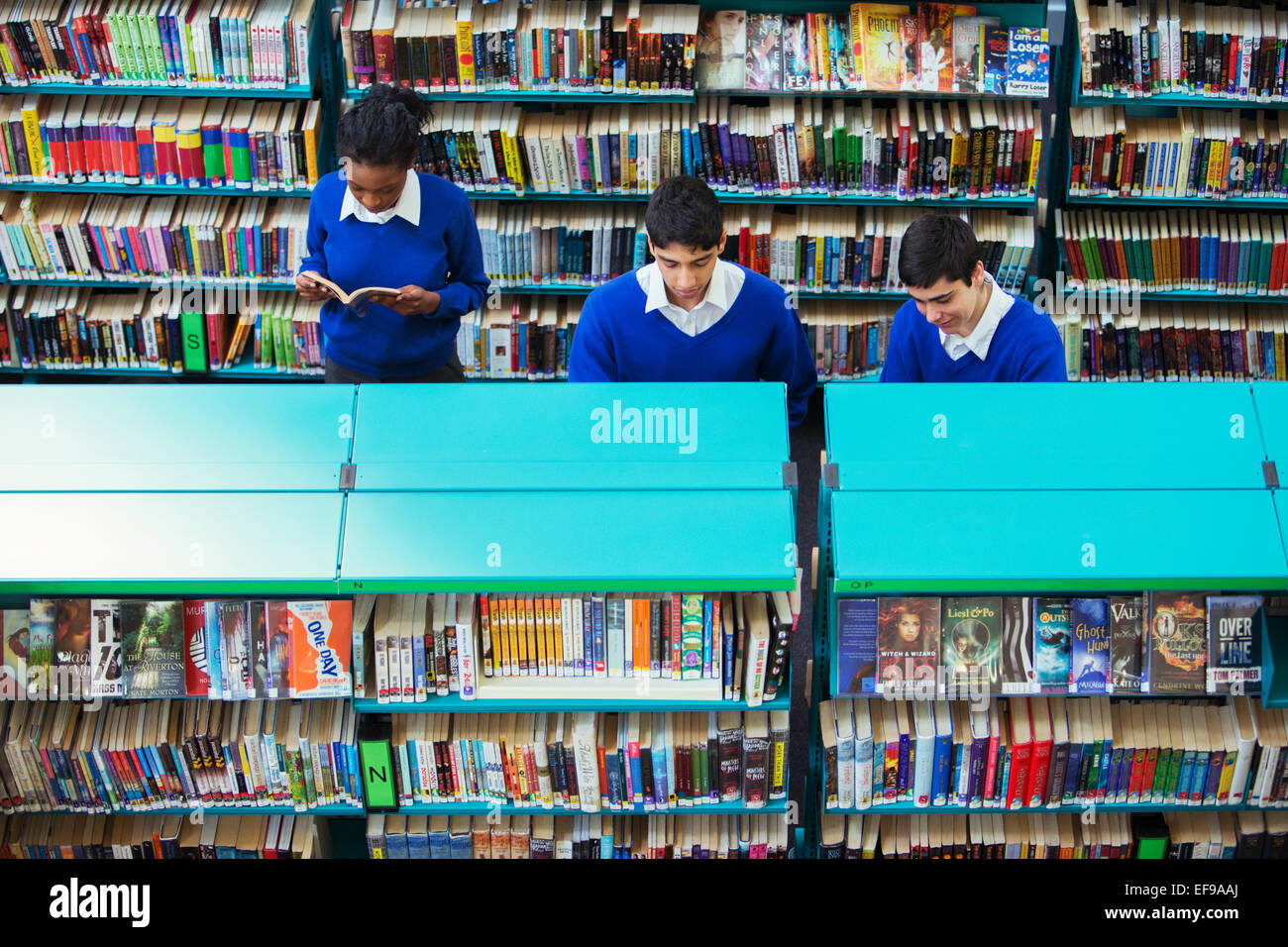 Pupil learning in classroom using book and tablet pc Stock Photo - Alamy