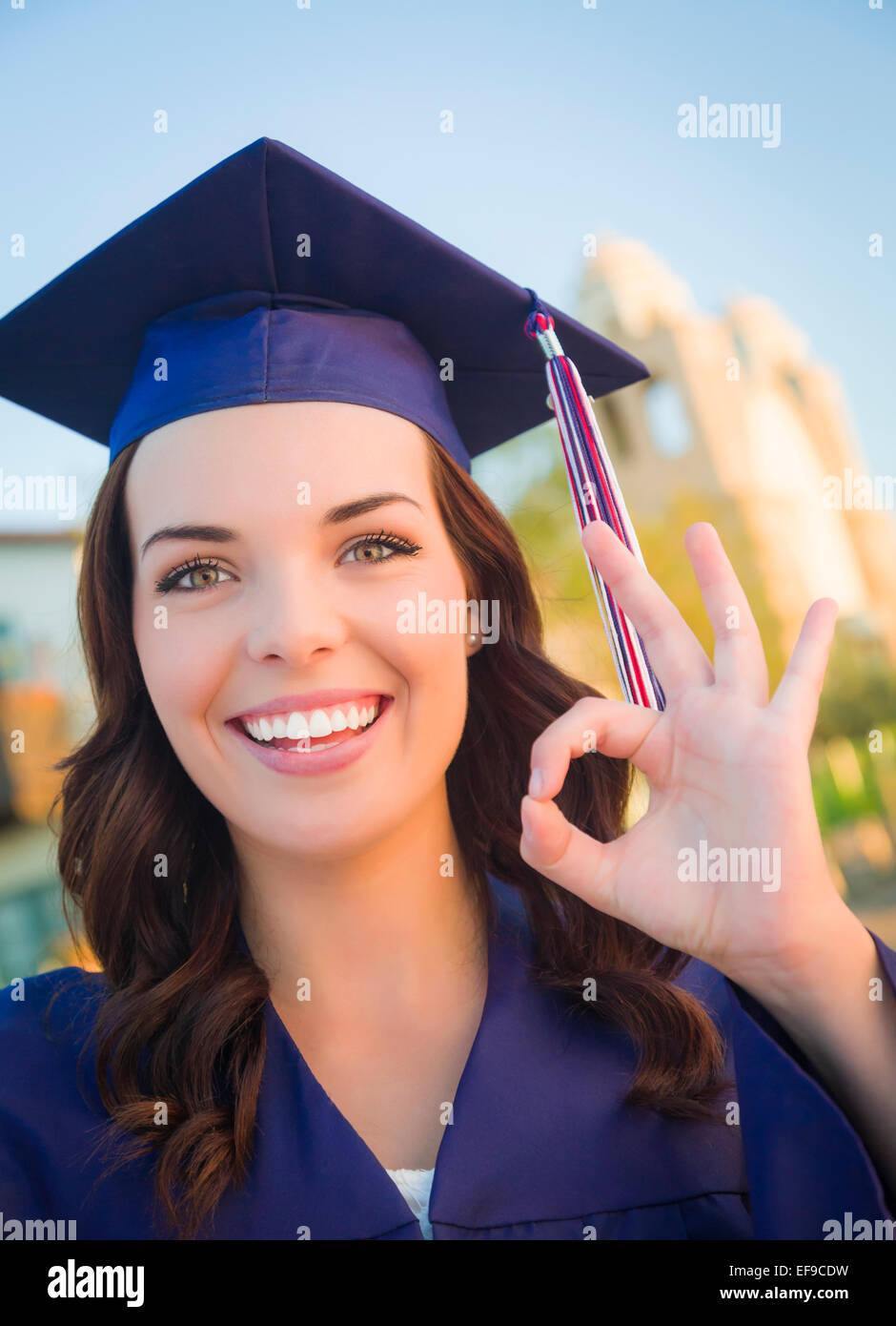 Happy Graduating Mixed Race Woman In Cap and Gown Celebrating on Campus ...