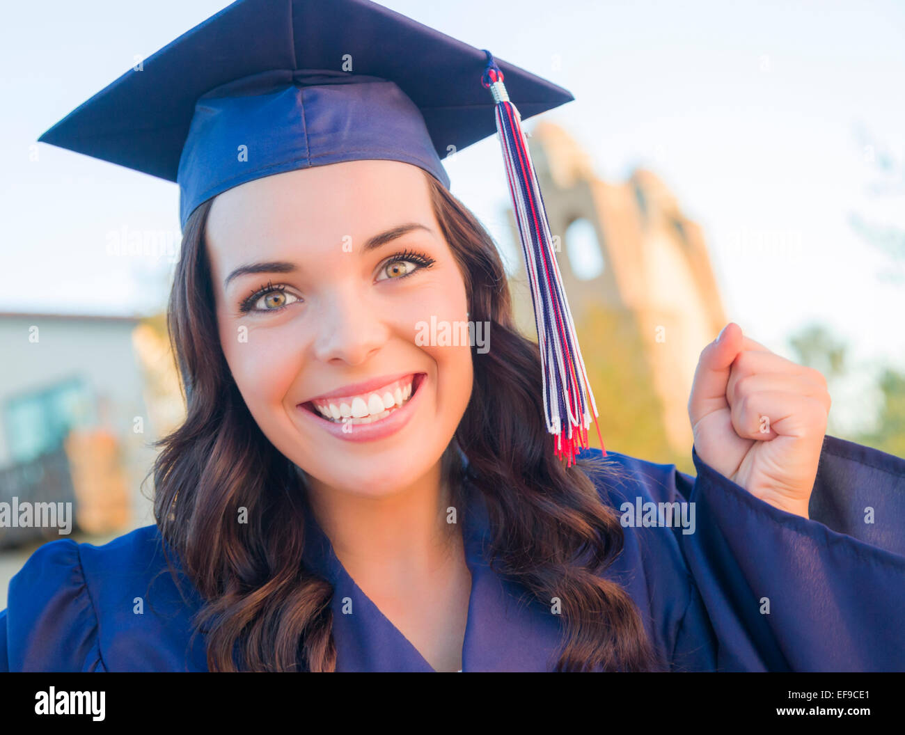 Happy Graduating Mixed Race Woman In Cap and Gown Celebrating on Campus ...
