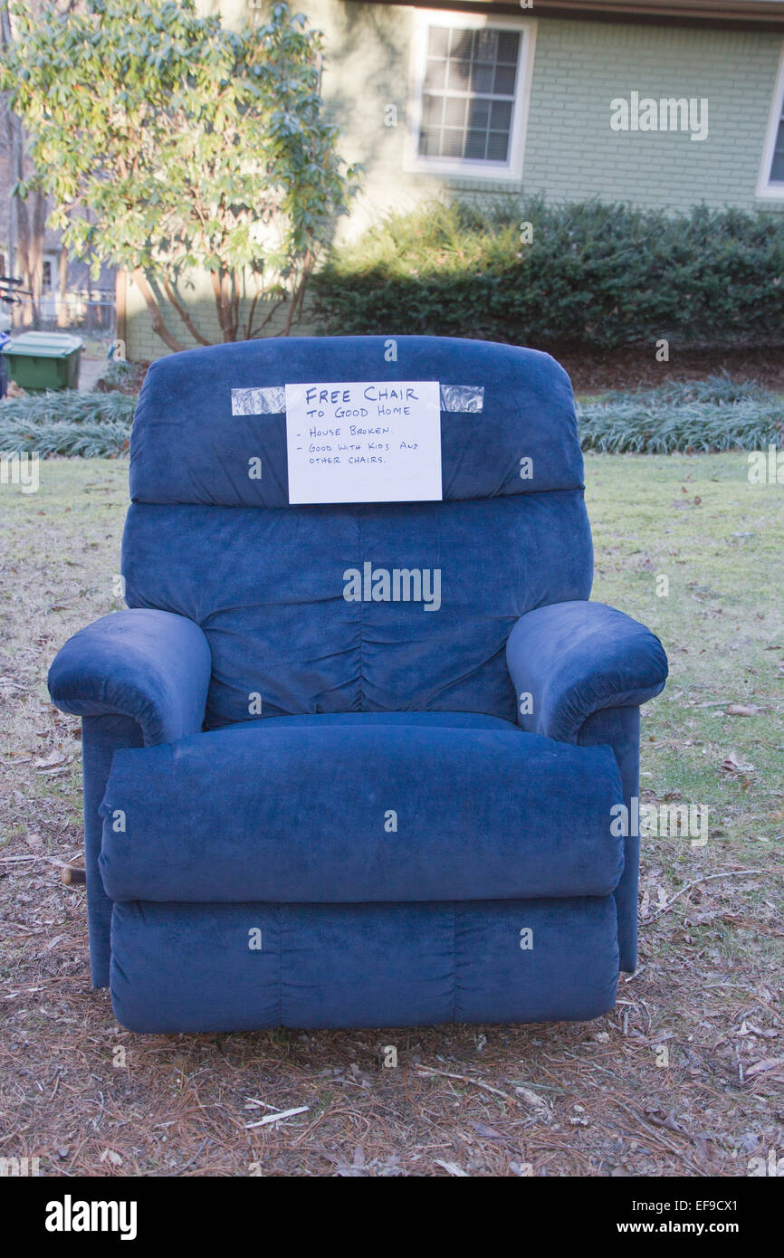 Close up of a colorful blue chair left by the side of the road with a ...