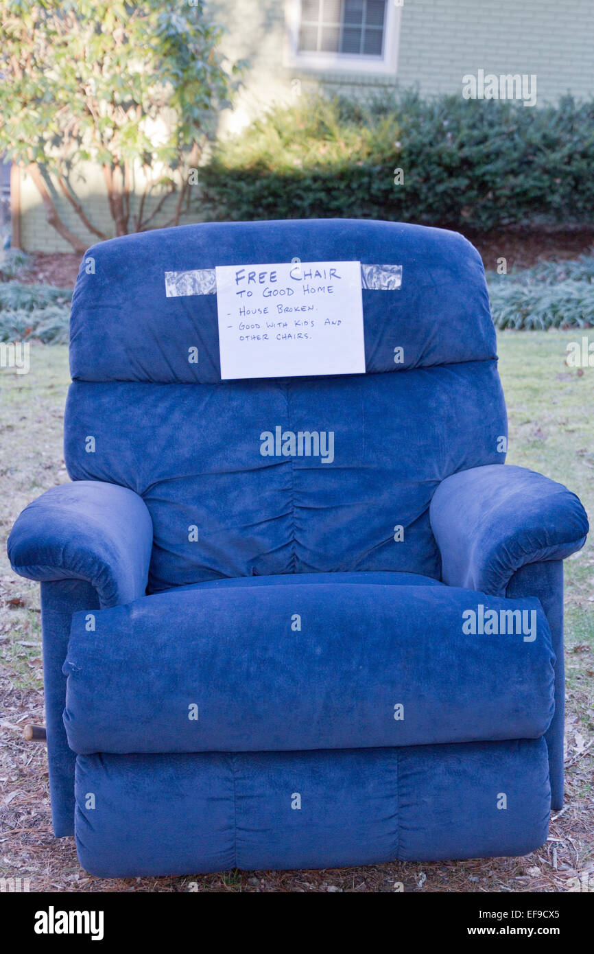 Close up of a colorful blue chair left by the side of the road with a ...