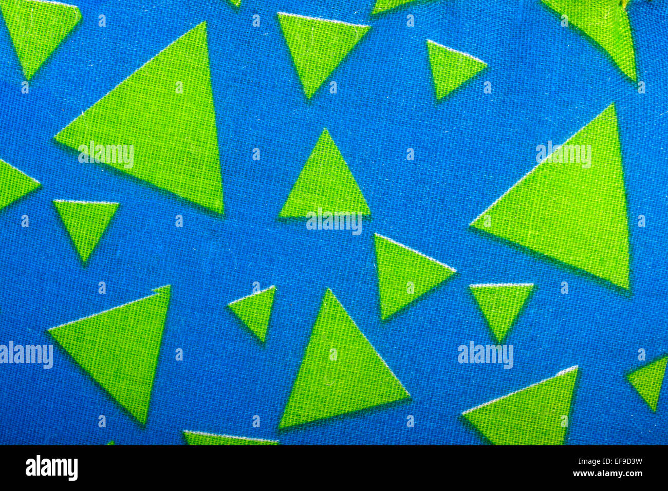 green material triangles on bright blue fabric Stock Photo - Alamy
