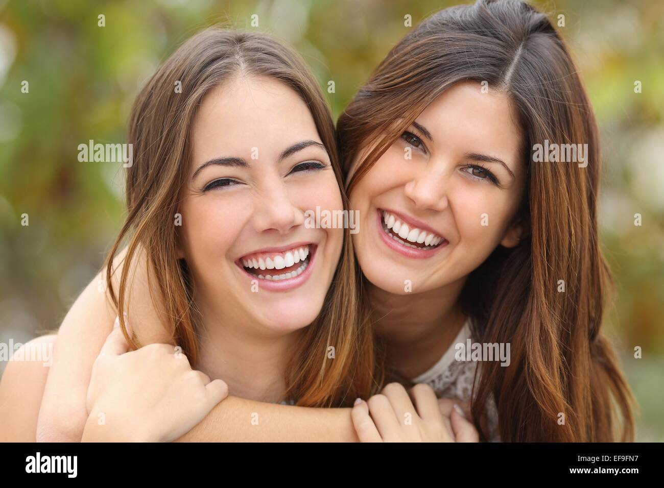 Two women friends laughing with a perfect white teeth with a green ...