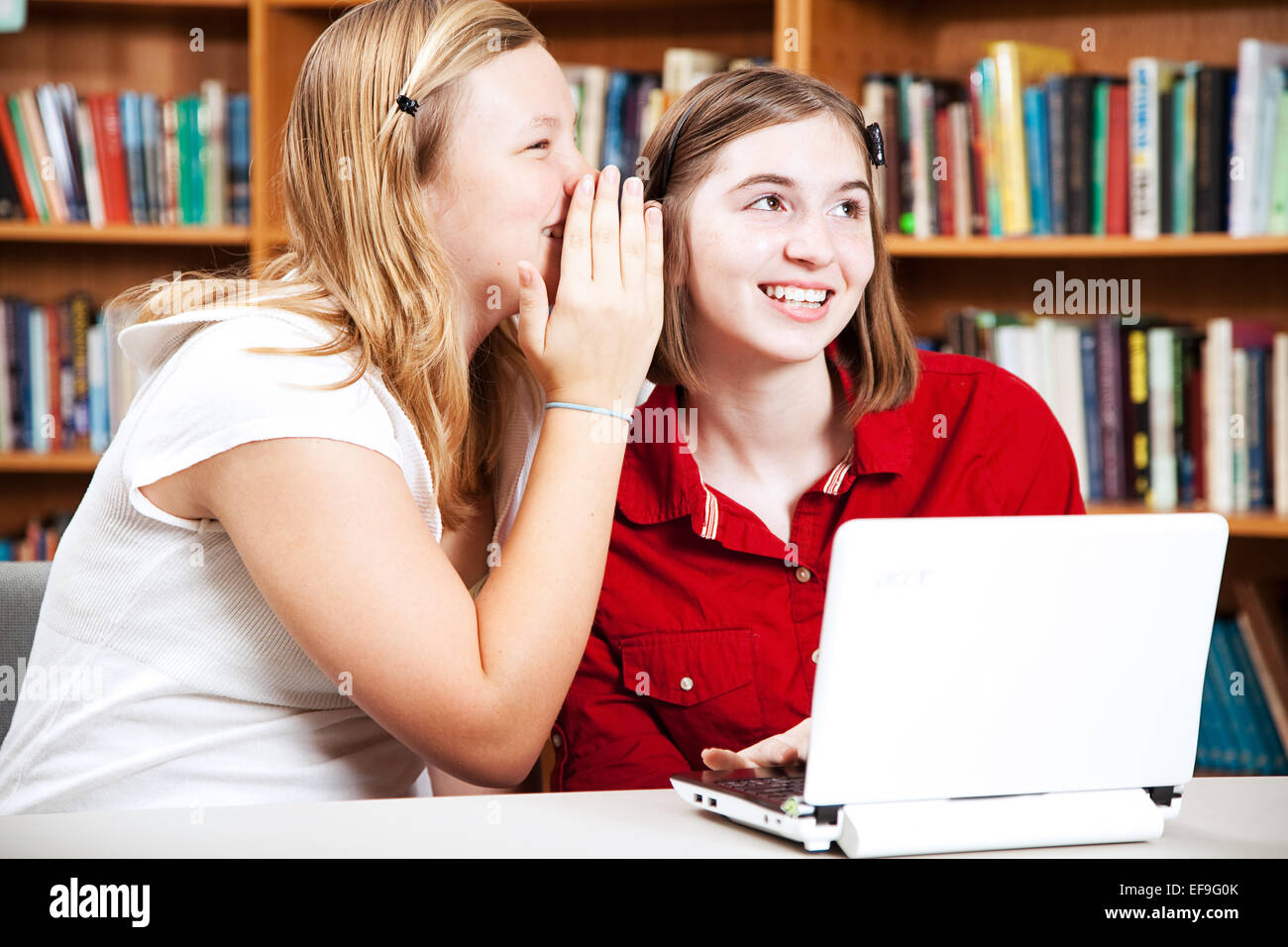 School girls whispering in the library Stock Photo - Alamy