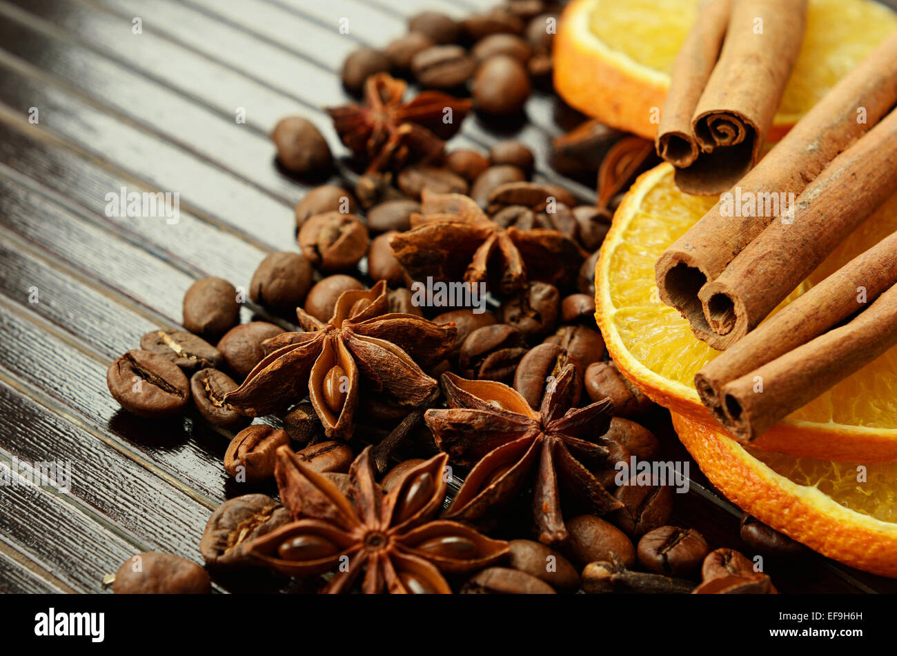 Fragrant spices with dry oranges and coffee on a dark striped ...