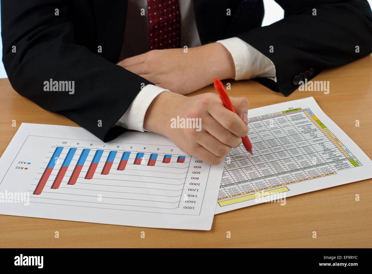 Businessman examining graphs at desk in his office Stock Photo - Alamy