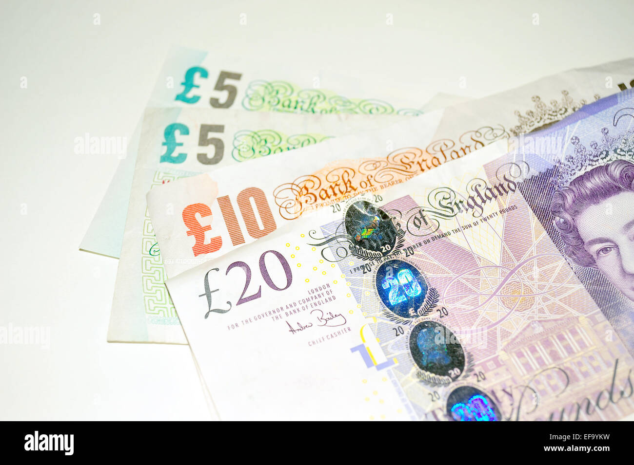 British £5, £10 and £20 currency notes photographed against a white ...