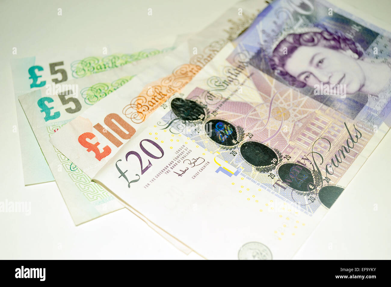 British £5, £10 and £20 currency notes photographed against a white ...
