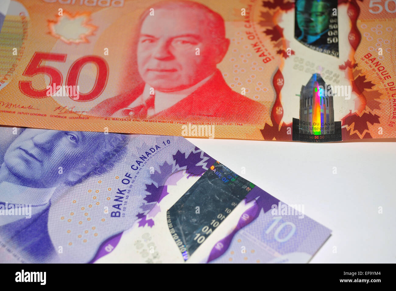 Canadian $50 and $10 currency notes photographed against a white ...