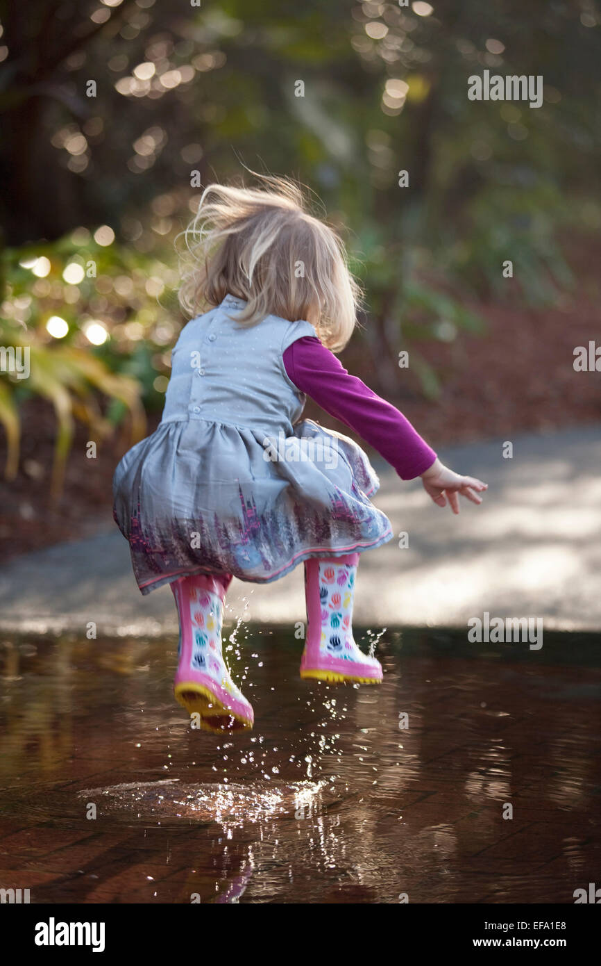A girl jumping in rain puddles Stock Photo - Alamy