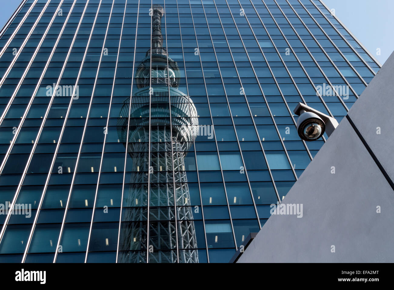 Tokyo Skytree is reflected in a tall building with a CCTV camera on a ...