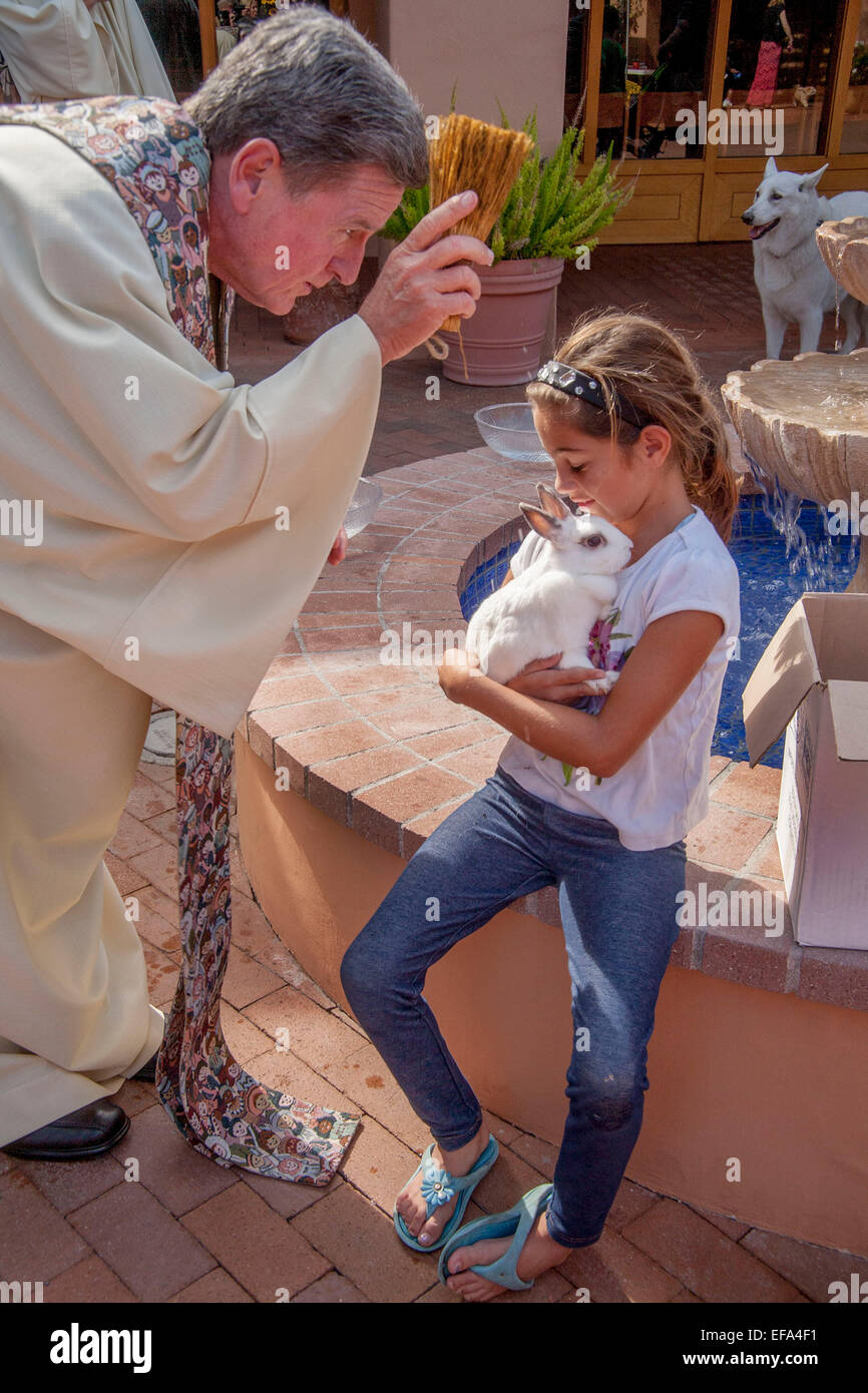 A blesses a little girl's pet rabbit at the Blessing of the Animals on ...