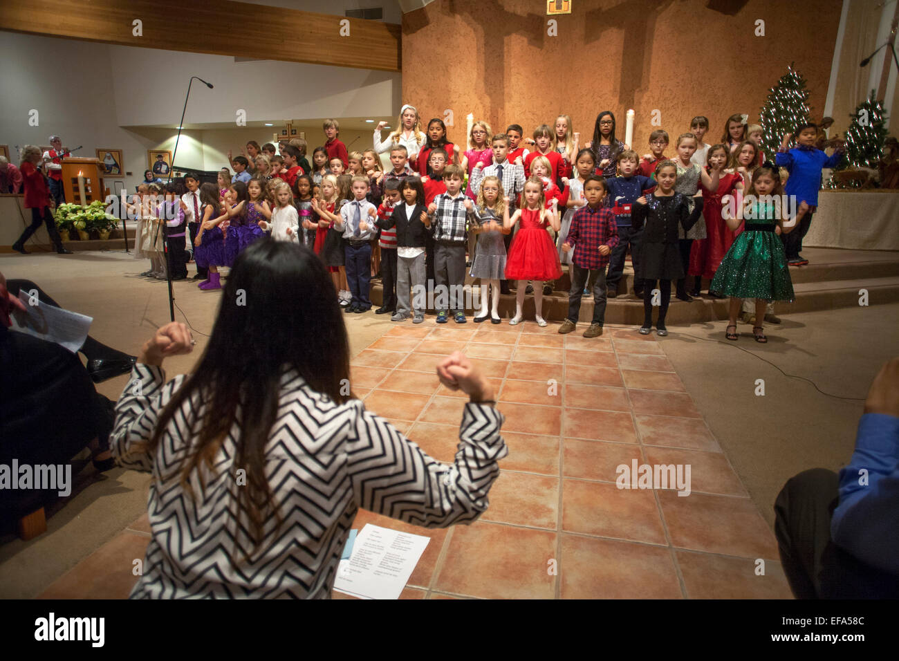 Multiracial young children sing carols during Christmas mass at St ...
