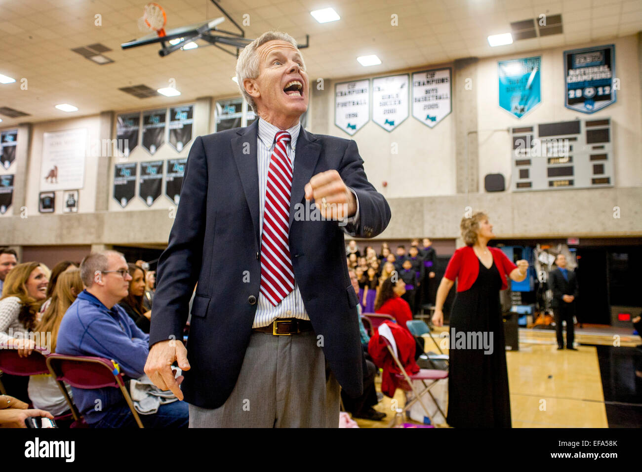 A school choir director gestures with encouragement while directing ...
