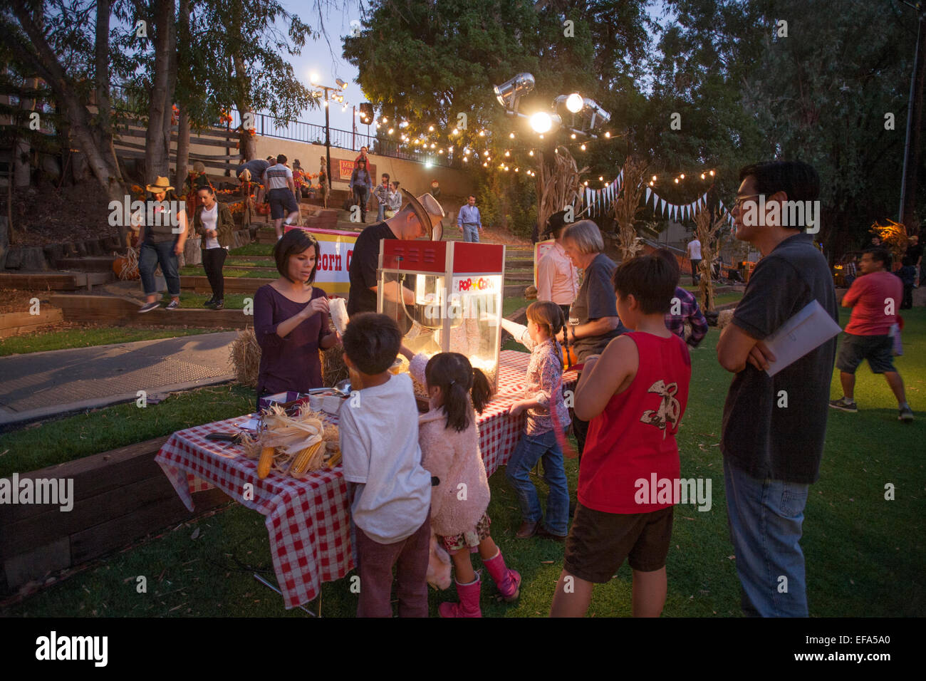 Schoolchildren gather for popcorn at an evening Harvest Fair at a ...