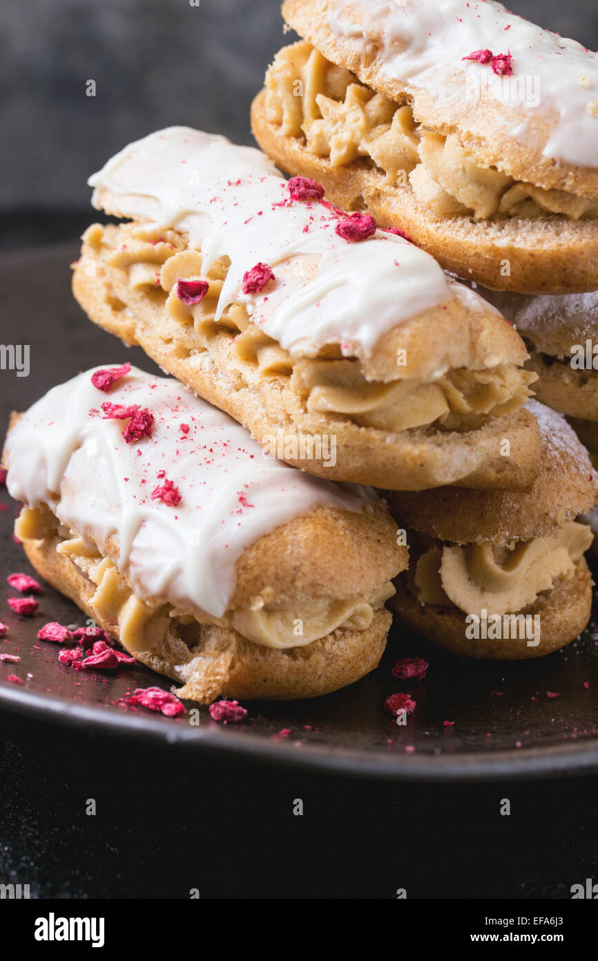 Ceramic plate of mini eclairs with white chocolate, served with dry ...
