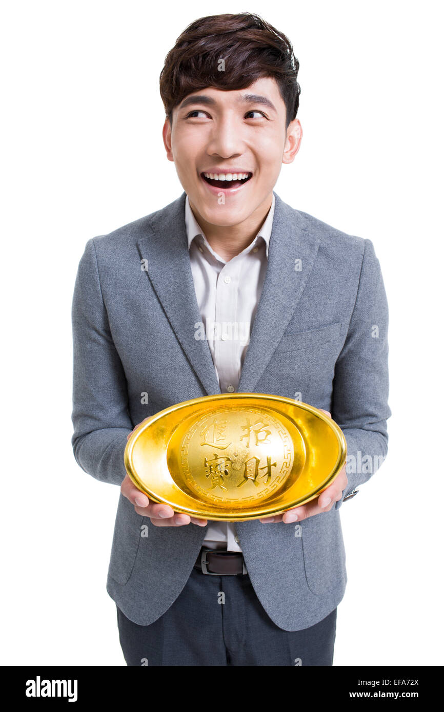Happy young man holding a large Chinese traditional currency yuanbao ...