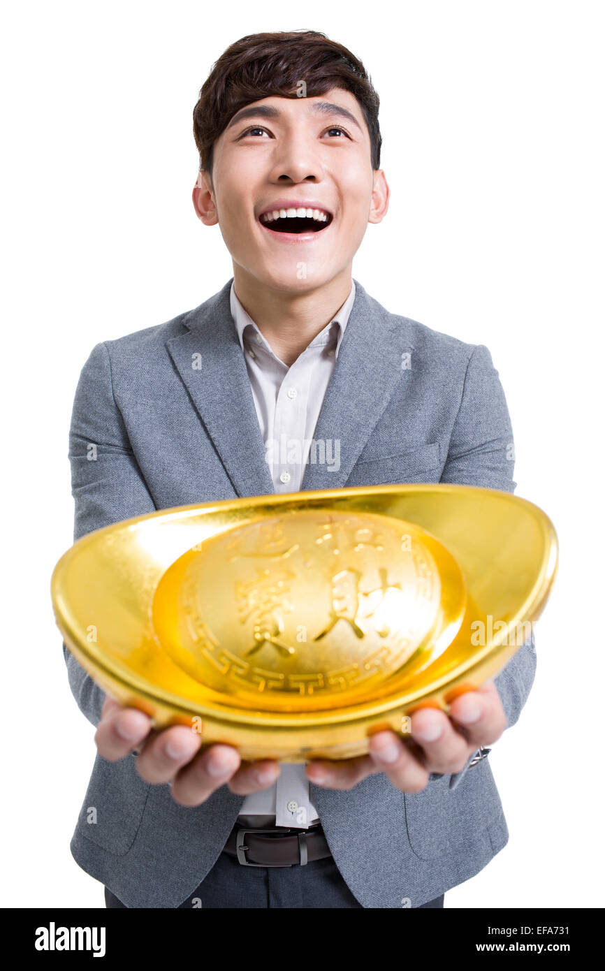 Happy young man holding a large Chinese traditional currency yuanbao ...