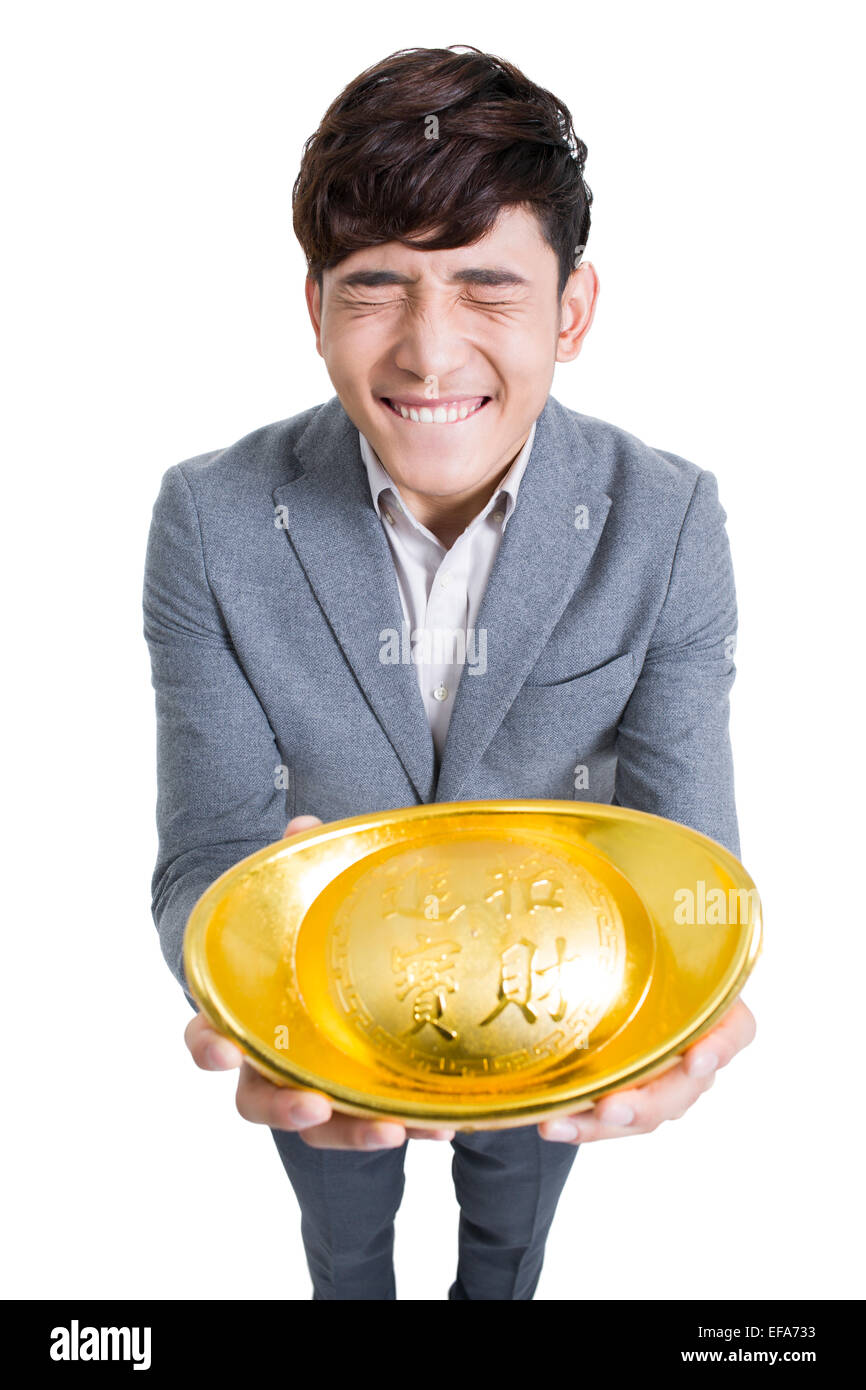 Happy young man holding a large Chinese traditional currency yuanbao ...