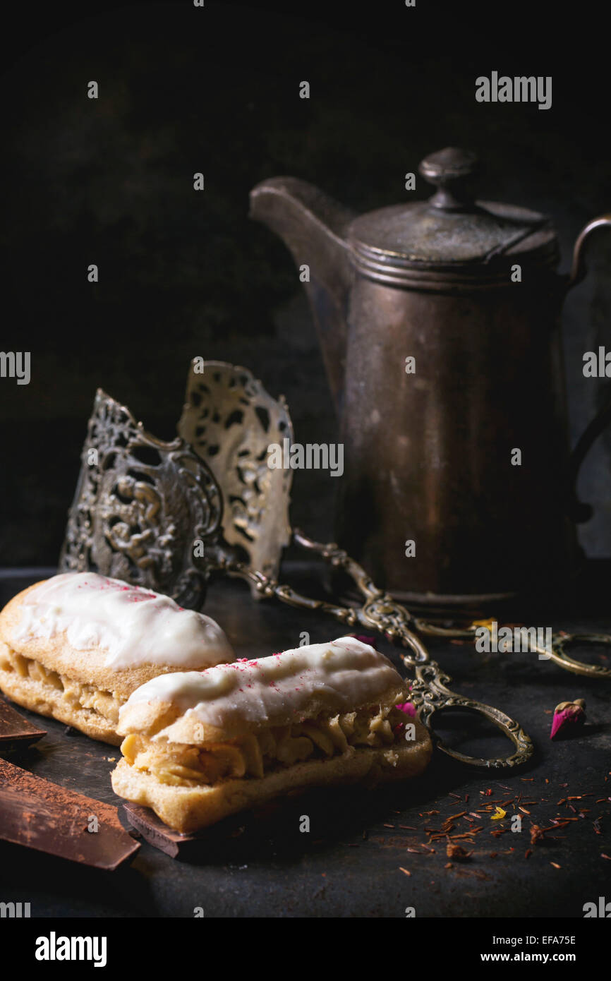 Tea drinking with eclairs and chopped chocolate, served with vintage ...