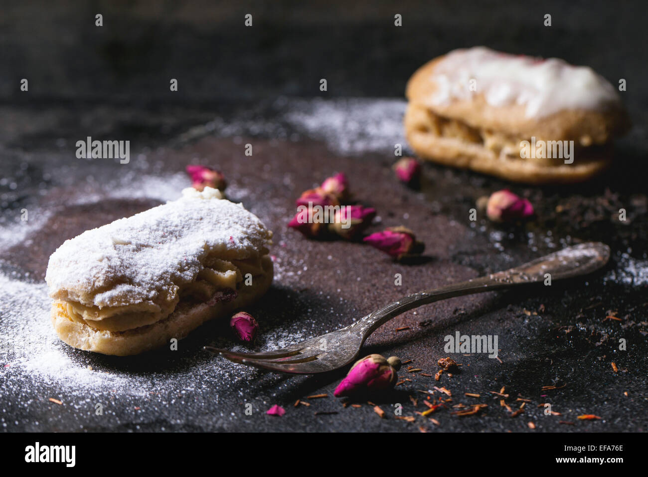 Eclairs with sugar powder, served with dry tea rose buds and vintage ...