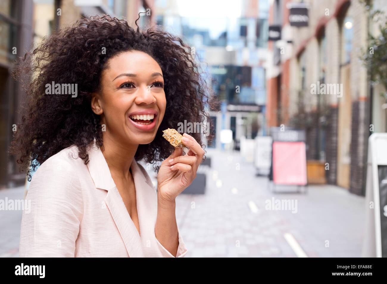 young woman enjoying a healthy snack in the street Stock Photo - Alamy
