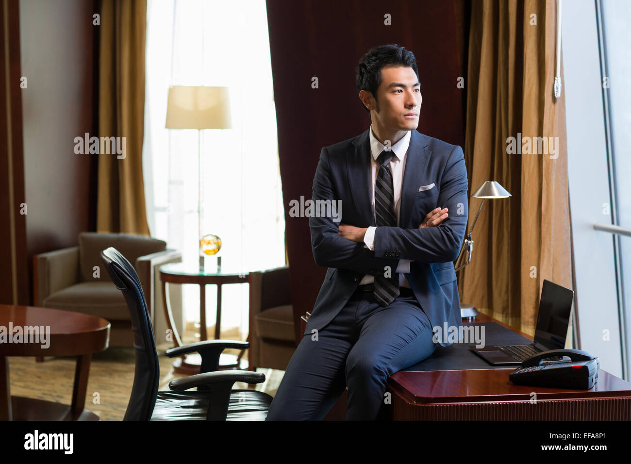 Successful businessman sitting in study Stock Photo - Alamy