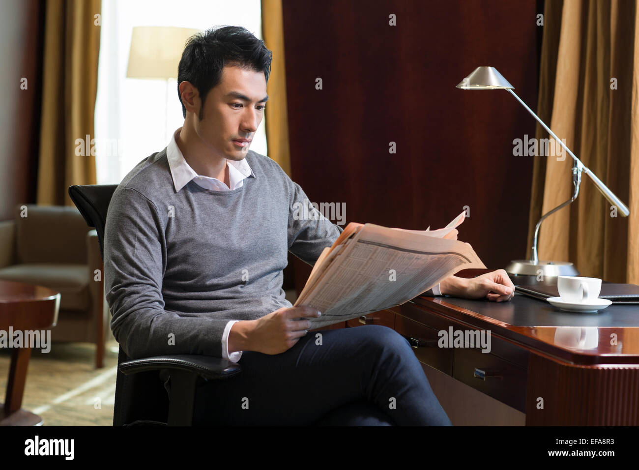 Businessman reading newspaper in armchair hi-res stock photography and ...