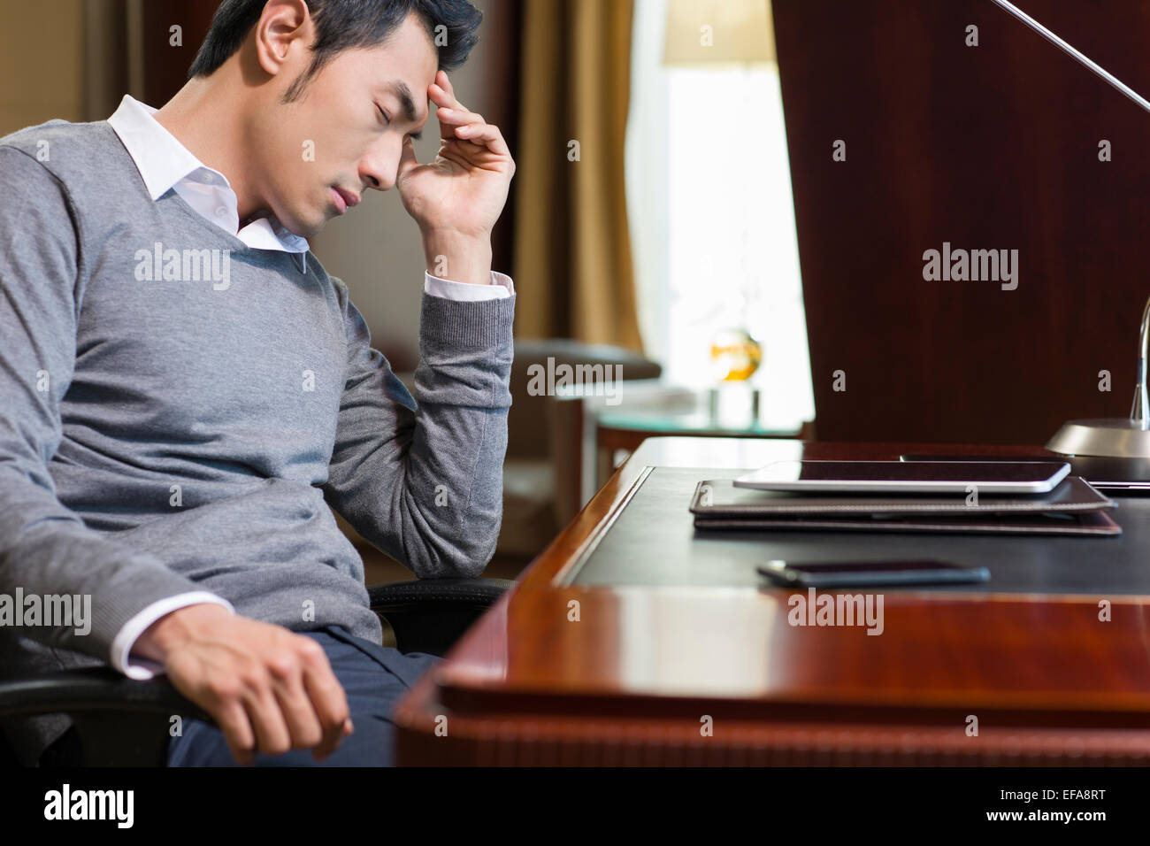 Tired businessman sitting in study Stock Photo - Alamy