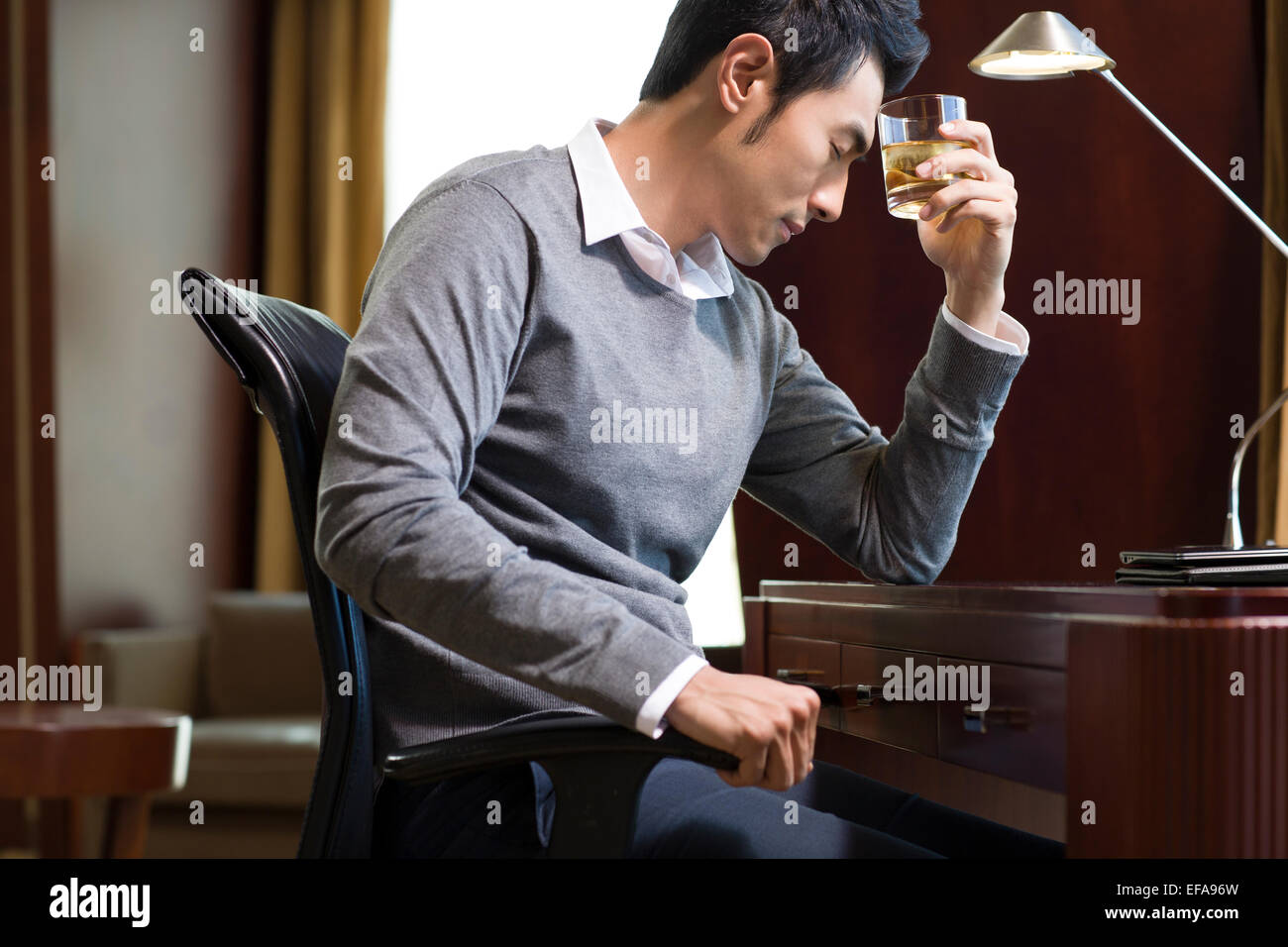 Tired businessman sitting in study Stock Photo - Alamy