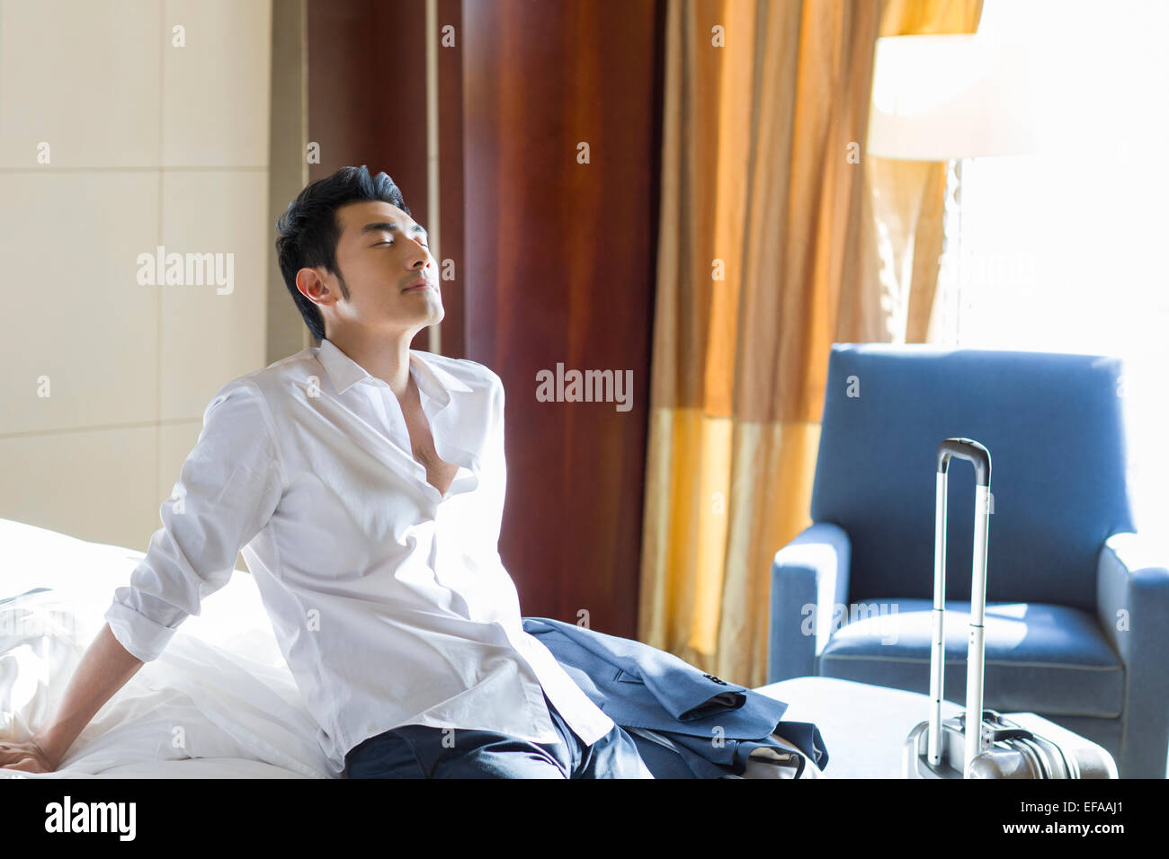 Young businessman resting in hotel room Stock Photo - Alamy