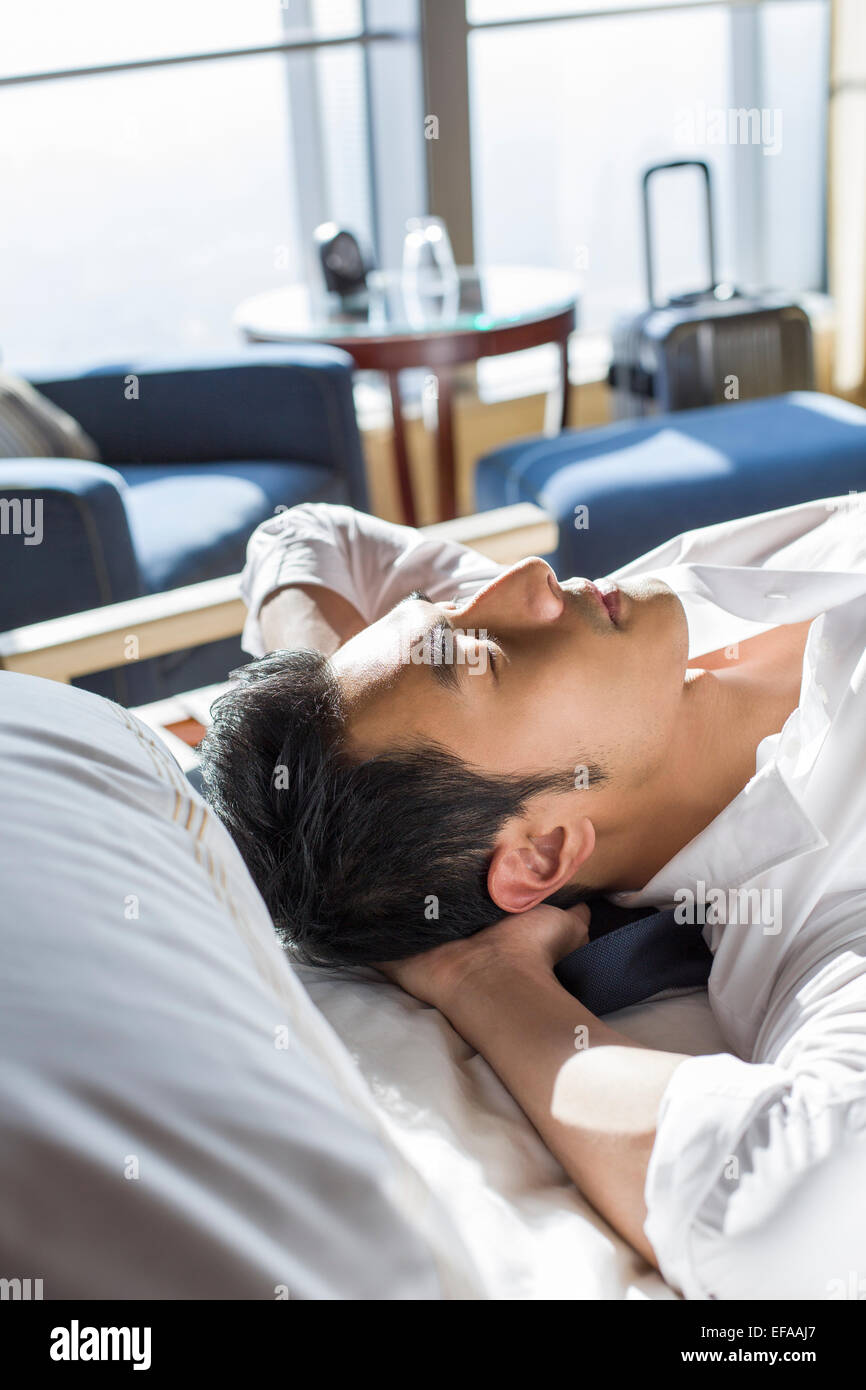Young businessman resting in hotel room Stock Photo - Alamy