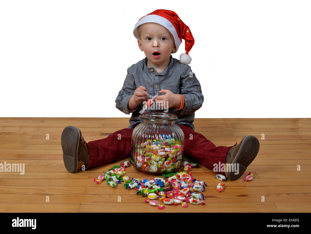 Baby with santa hat eat a lot of sweets Stock Photo - Alamy