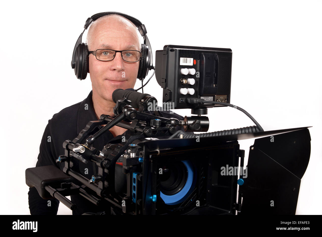 man standing with a camera on a tripod Stock Photo - Alamy