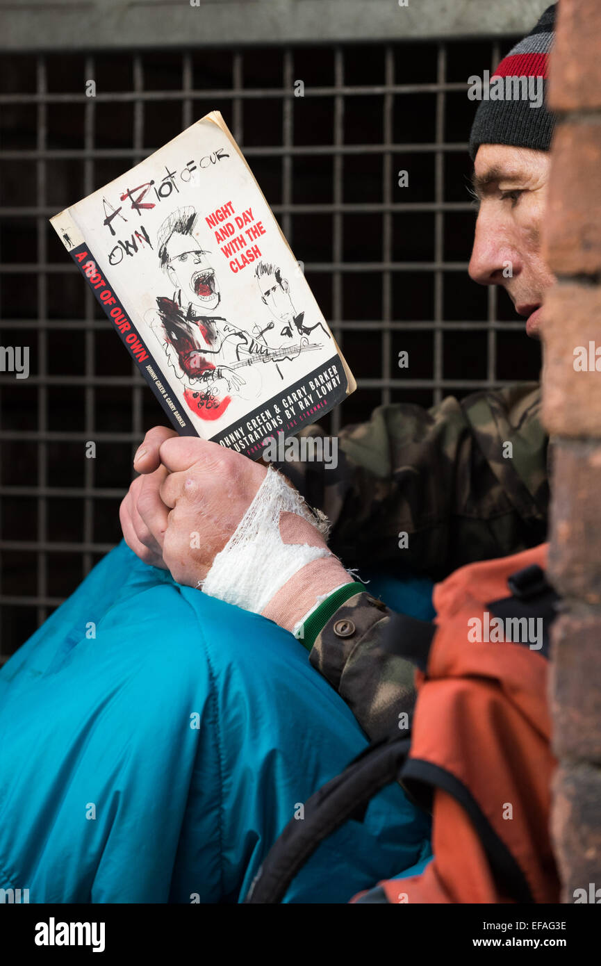 A homeless man reading a book while in his sleeping bag Stock Photo - Alamy