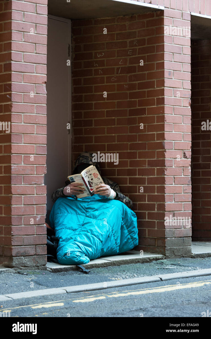 A homeless man reading a book while in his sleeping bag Stock Photo - Alamy