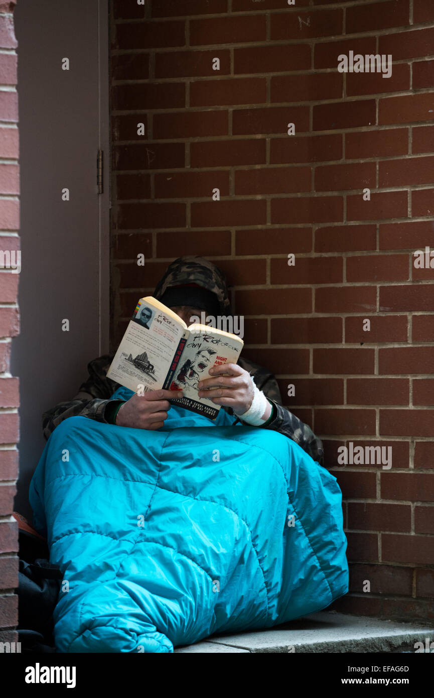 A homeless man reading a book while in his sleeping bag Stock Photo - Alamy