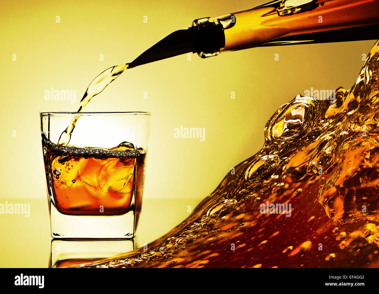 alcoholic drink being poured into a glass with ice Stock Photo - Alamy