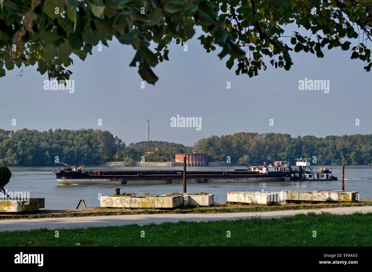 Tugboat with ship pass along the riverside park in Ruse town, Bulgaria ...