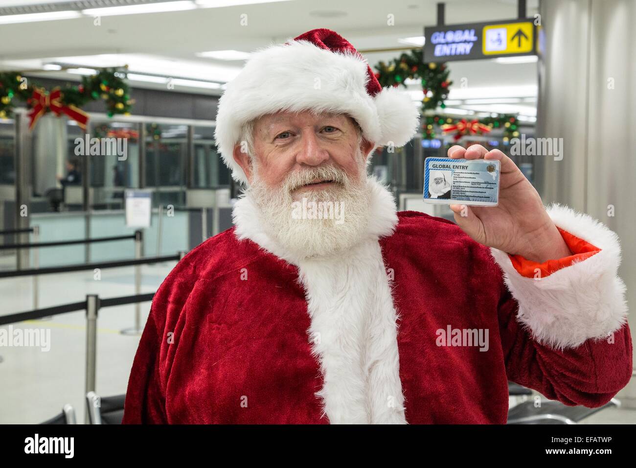 Santa Claus holds a U.S. immigration Global Entry pass as he prepares ...