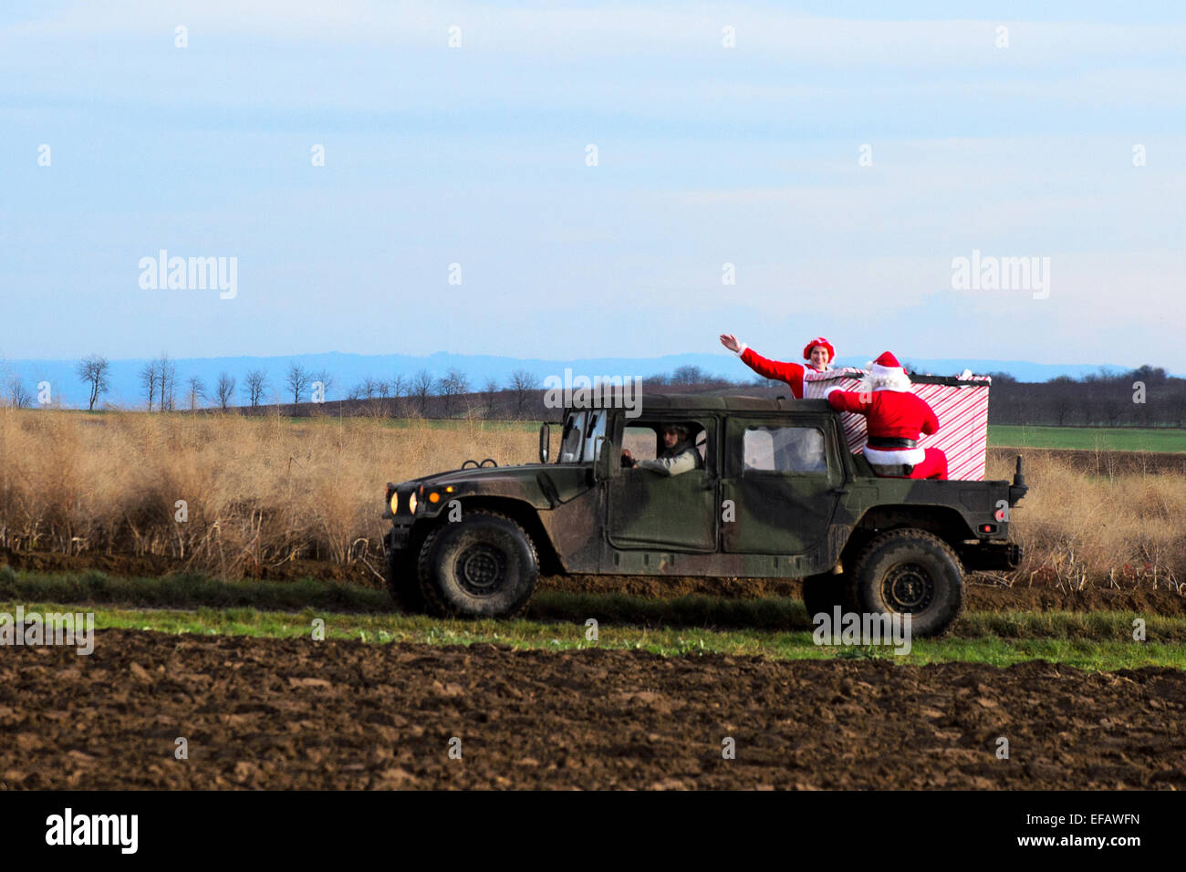 A US Air Force airman dressed as Santa Claus drives in the back of a ...