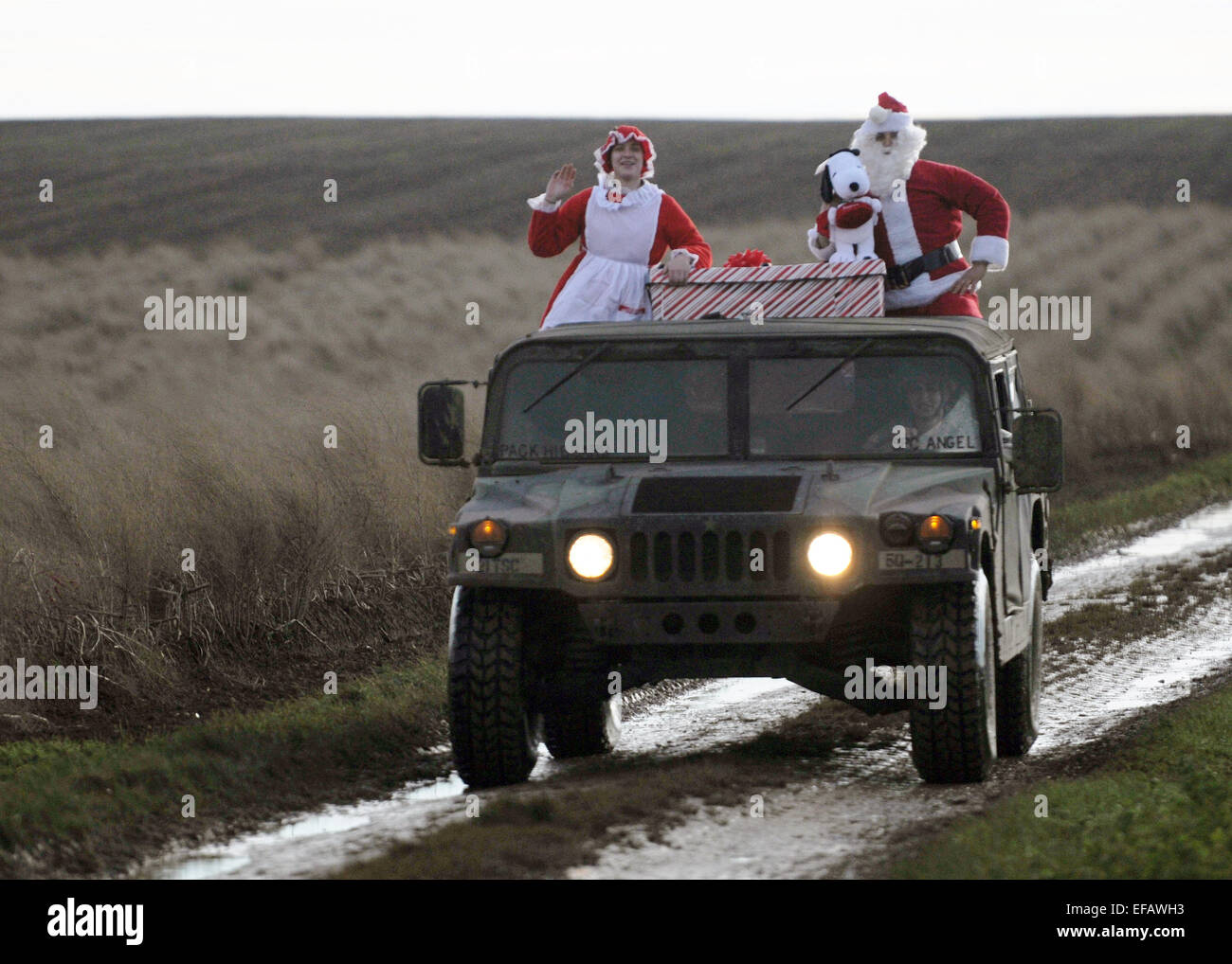 A US Air Force airman dressed as Santa Claus drives in the back of a ...