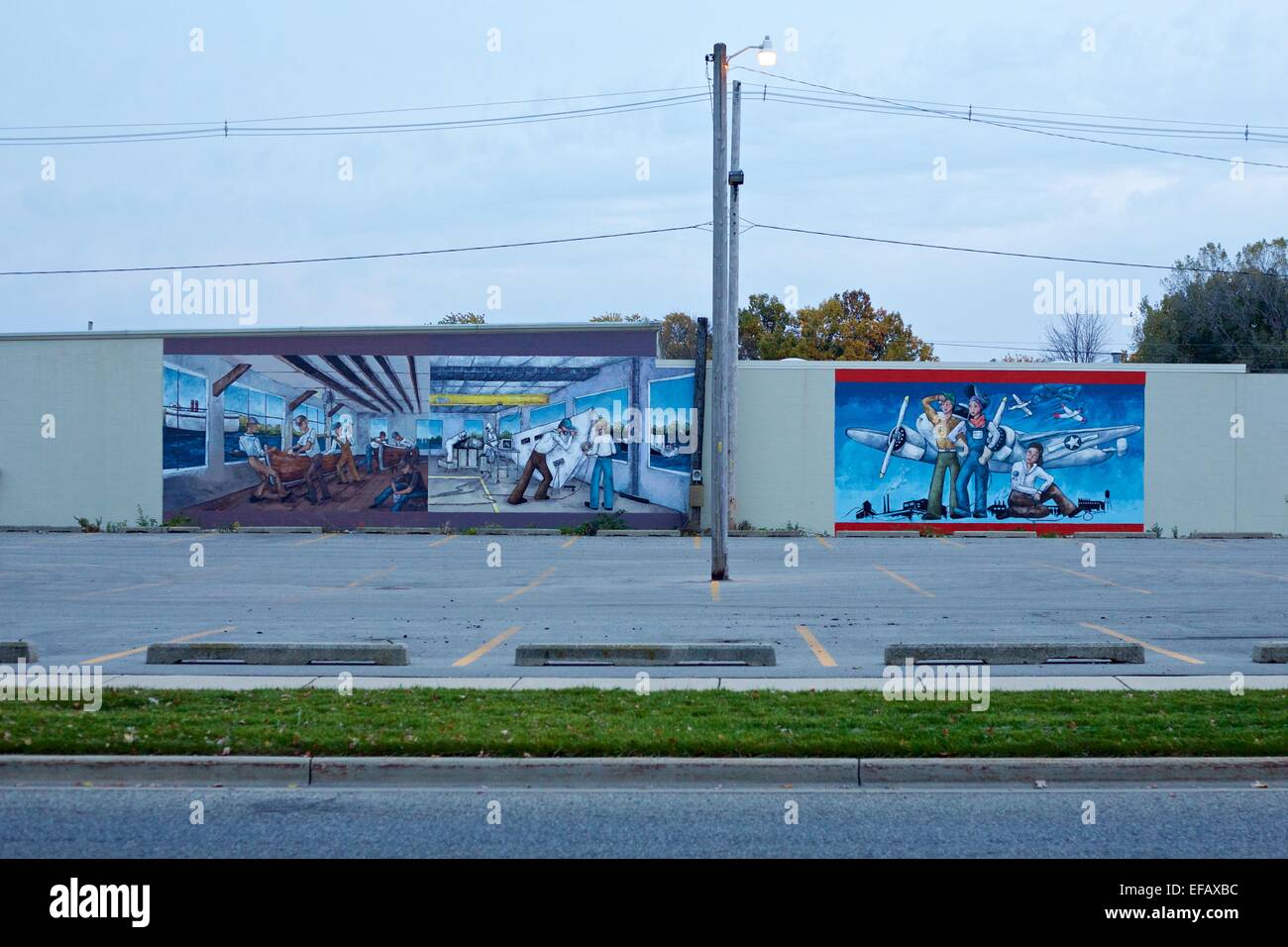 Painted murals on the side of a commercial building depicting boat and ...