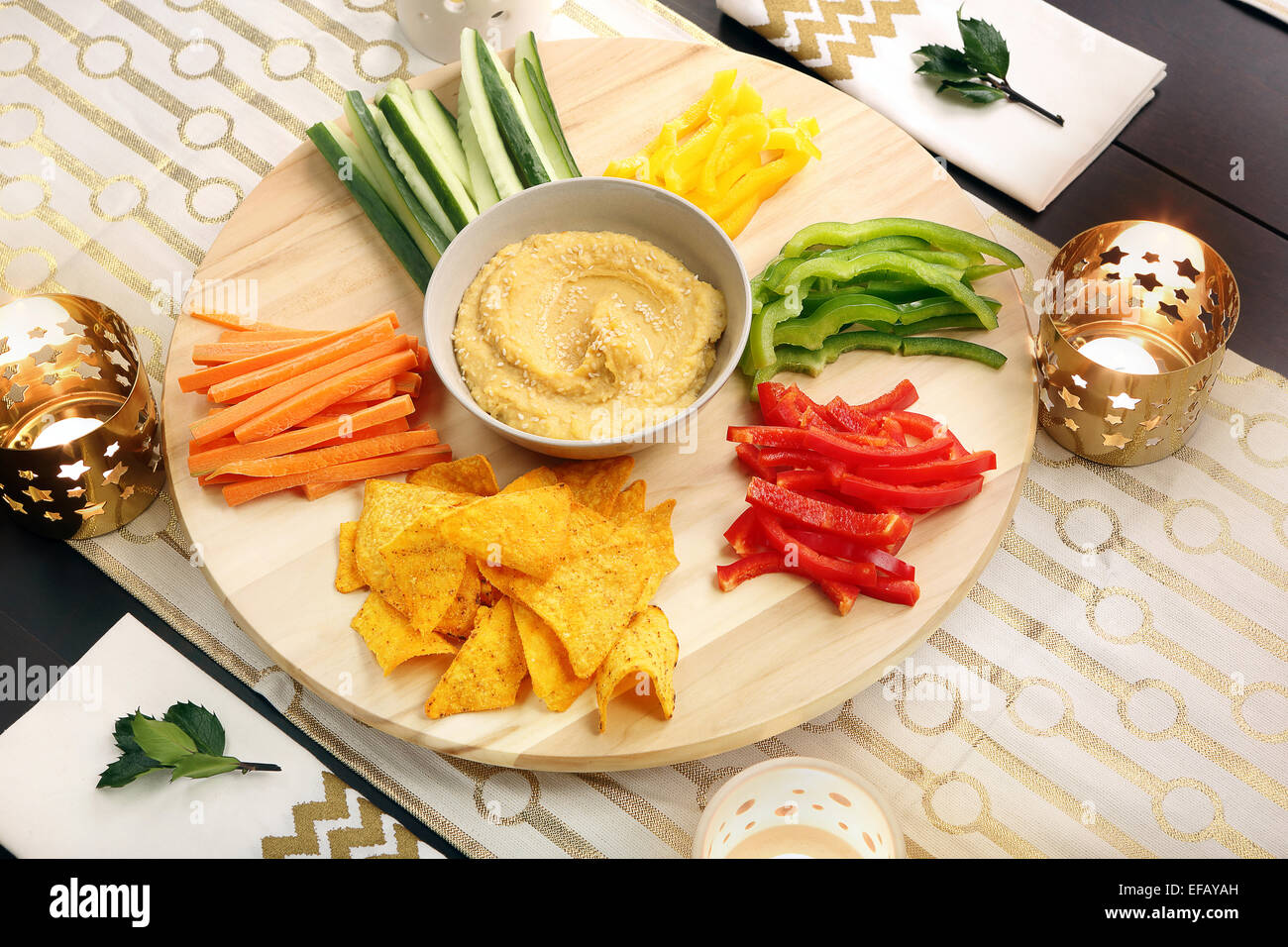 Hummus with vegetables on a wooden swivel table Stock Photo - Alamy