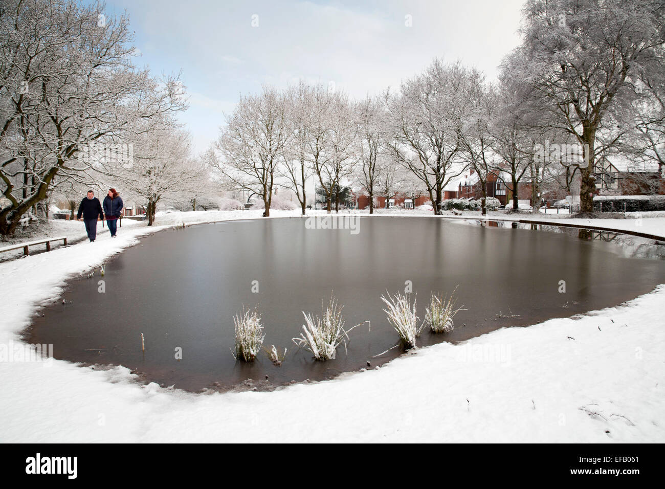 Snow covered Baddesley Ensor in North Warwickshire, UK. Two people ...